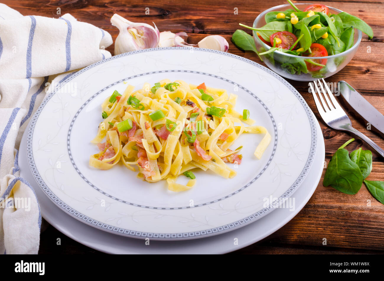 Italian pasta with spring onion, garlic and bacon with salad Stock ...