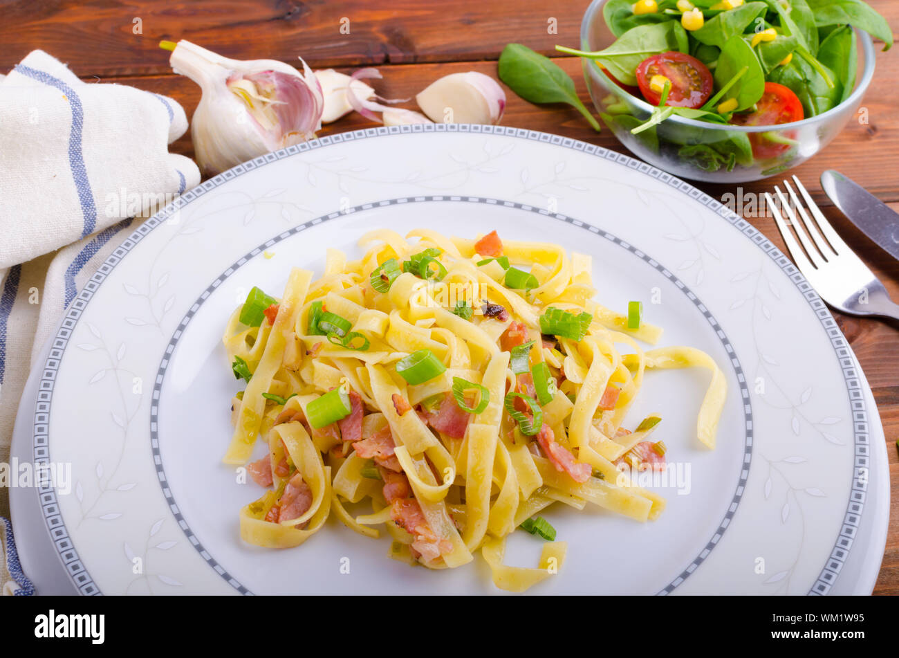 Italian pasta with spring onion, garlic and bacon with salad Stock ...