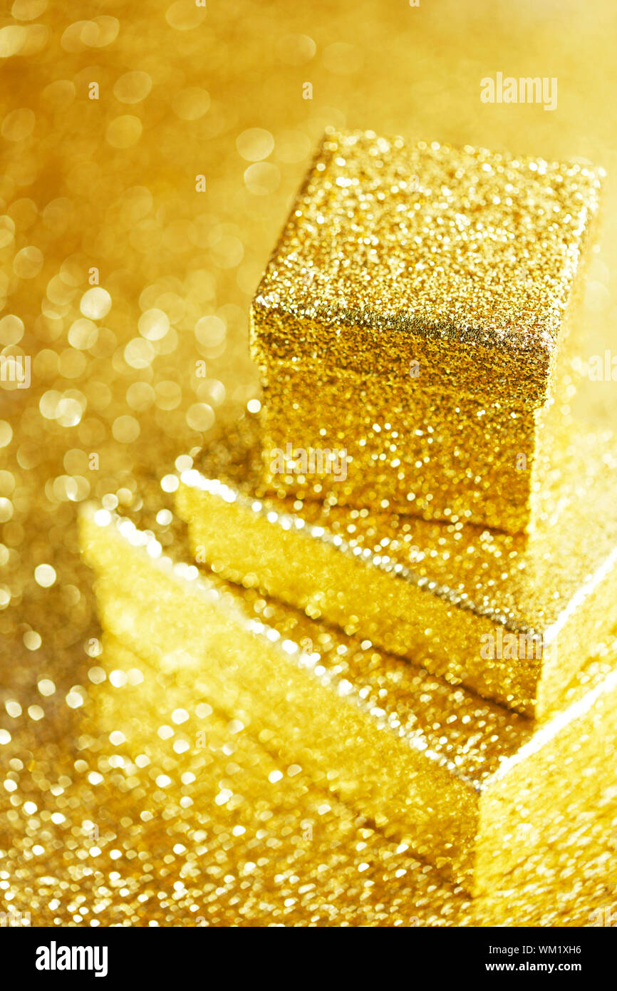 Decorative golden boxes with holiday gifts on shiny glitter background ...