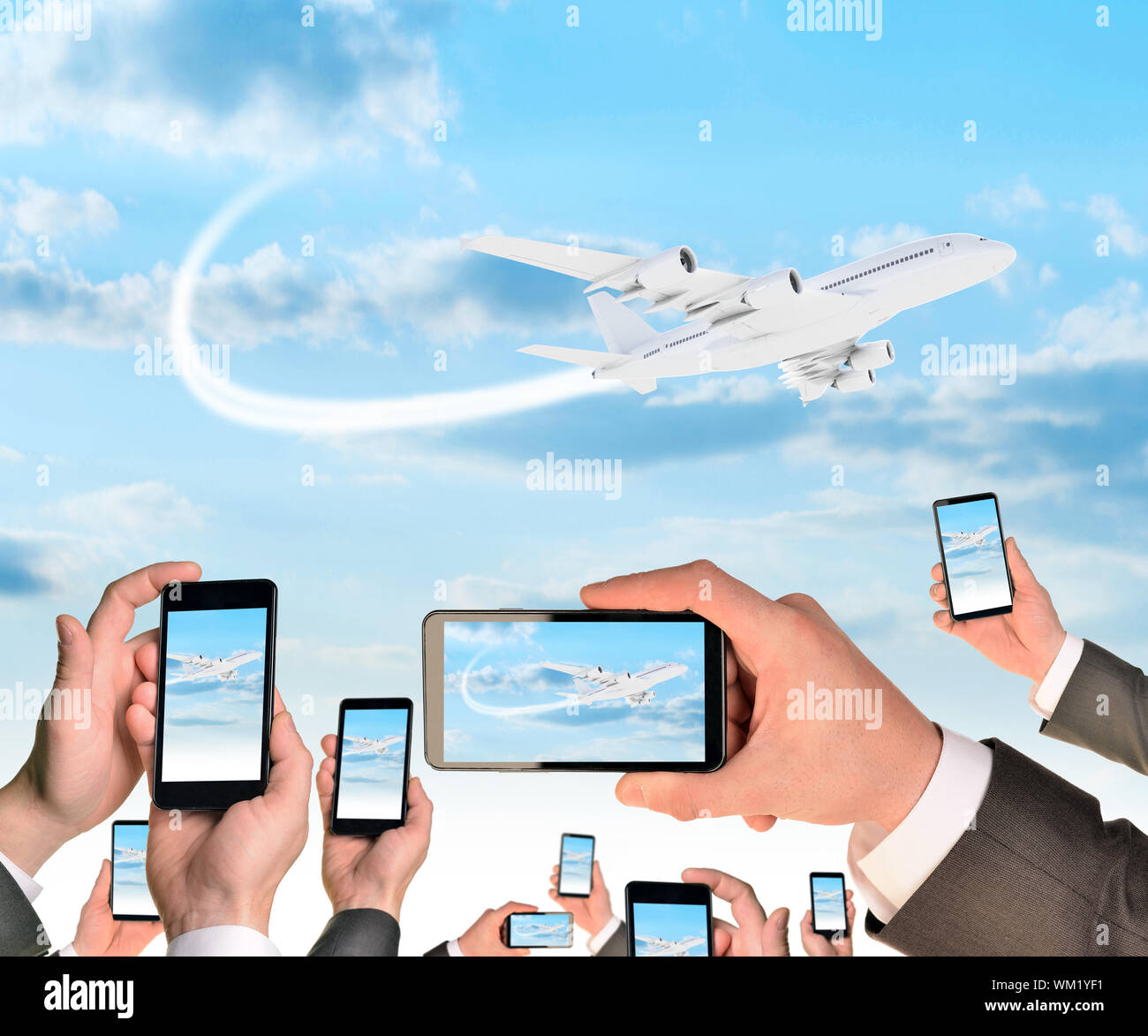 Hands holding smart phones and shoot video as flying airplane. Sky with ...