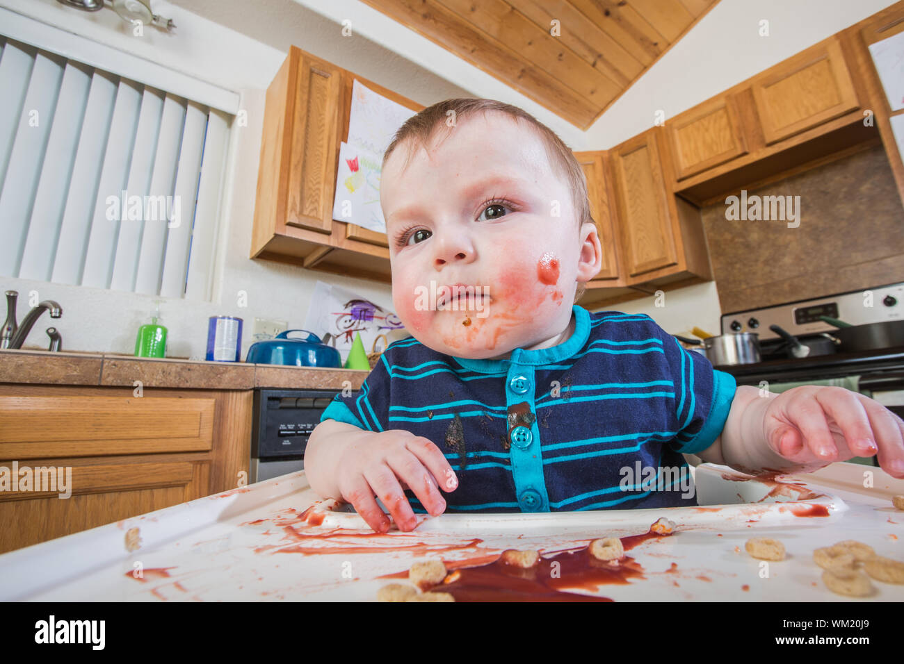A messy child eats breakfast in the kitchen Stock Photo - Alamy