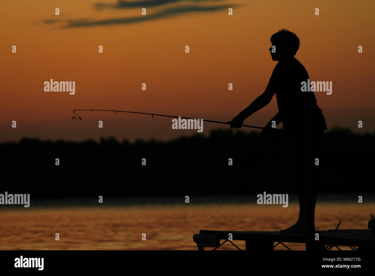 Boy fishing off dock hi-res stock photography and images - Alamy