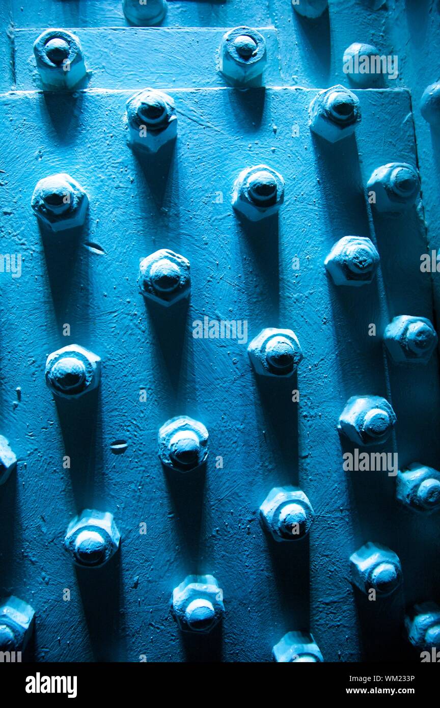 blue metal wall with multiple big screws Stock Photo - Alamy