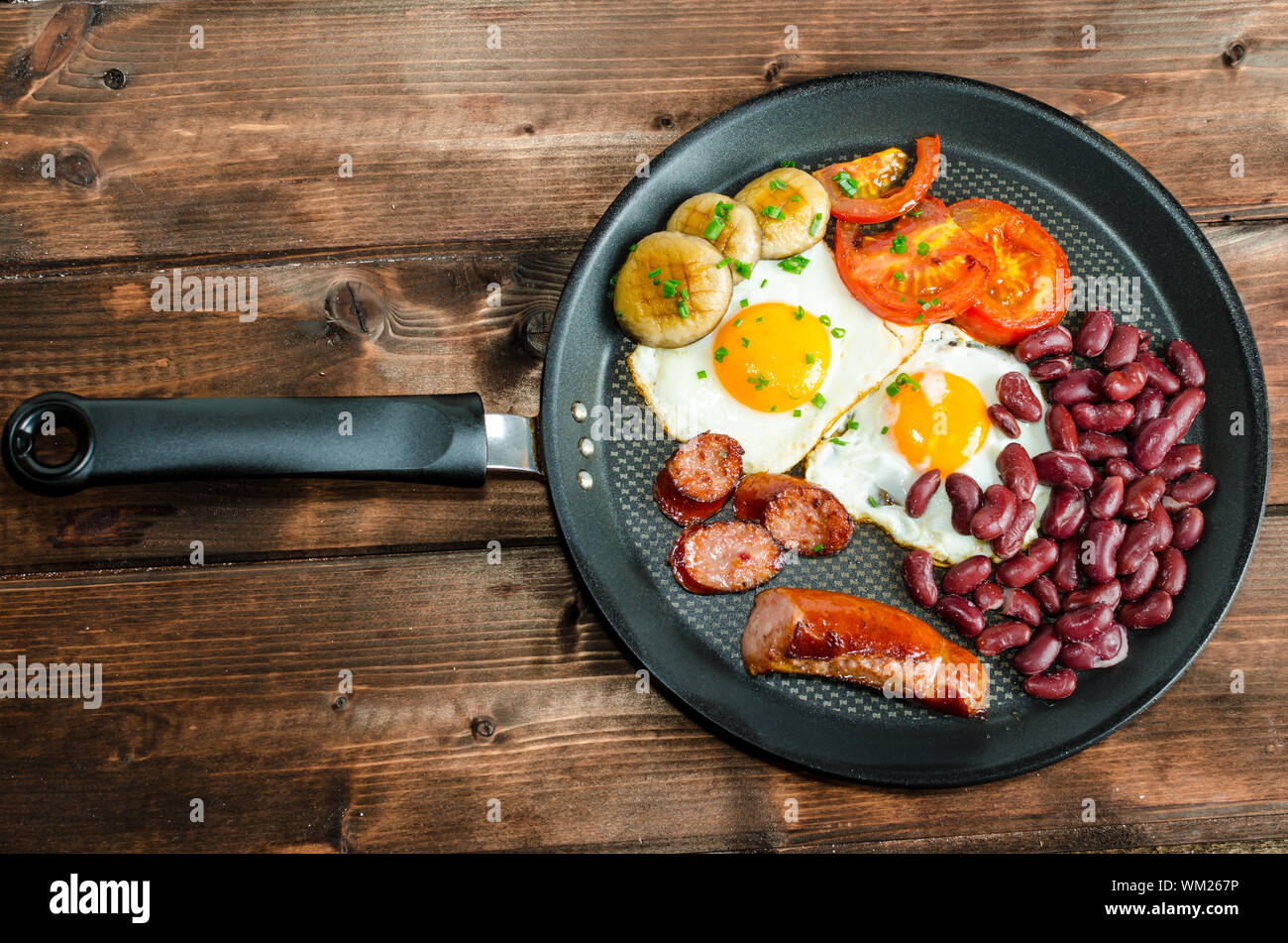 English breakfast on frying pan and wood table Stock Photo - Alamy