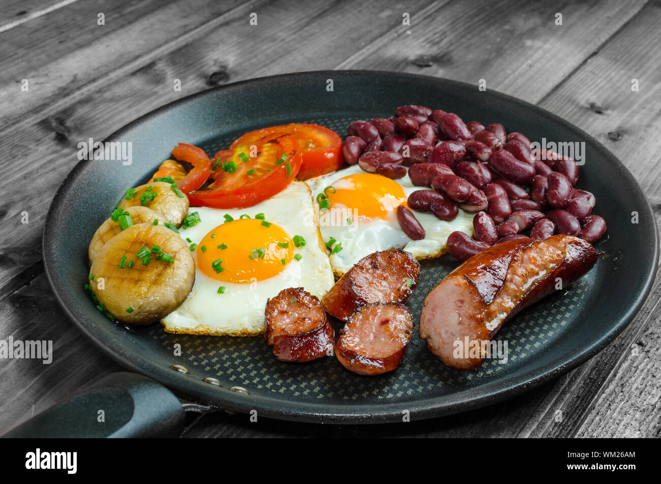 English breakfast on frying pan and wood table Stock Photo - Alamy