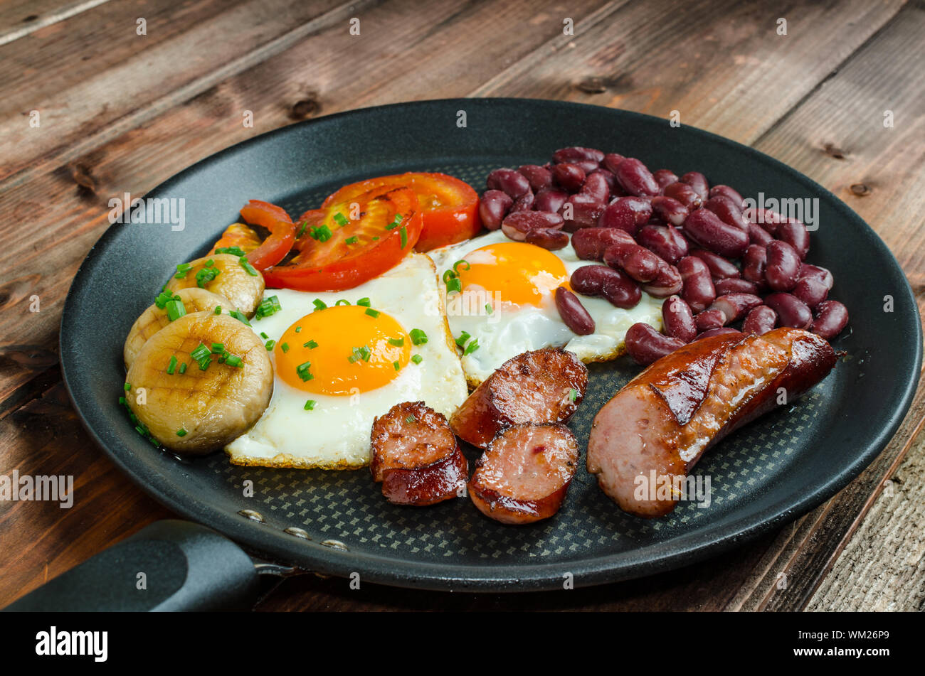 English breakfast on frying pan and wood table Stock Photo - Alamy