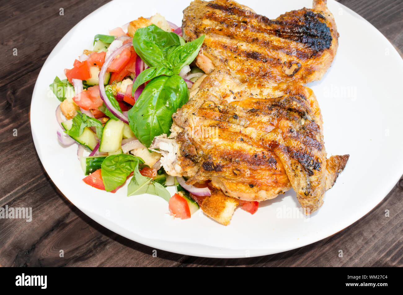 Chicken under a brick with panzanella salad. Pollo al mattone Stock ...