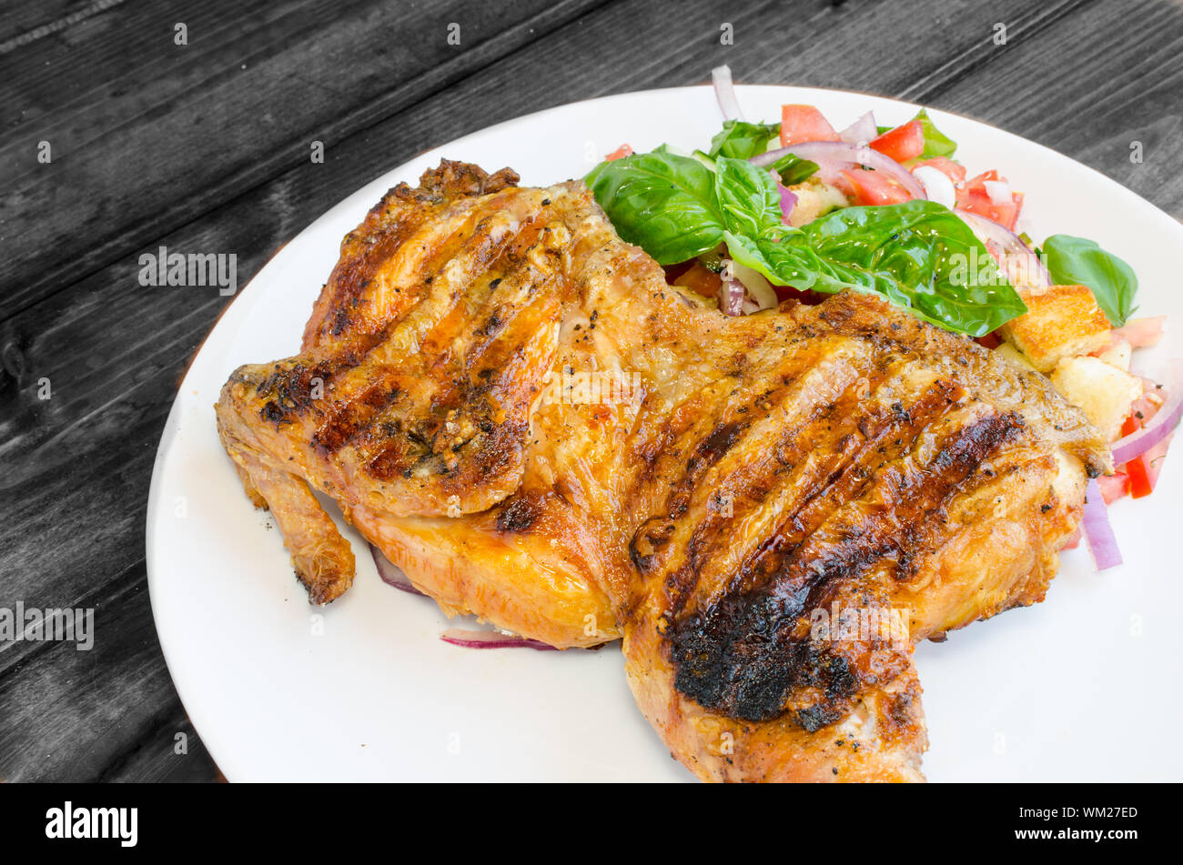 Chicken under a brick with panzanella salad. Pollo al mattone Stock ...