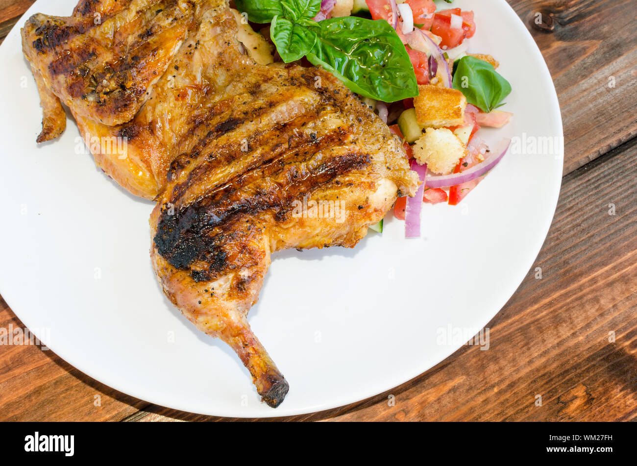 Chicken under a brick with panzanella salad. Pollo al mattone Stock ...