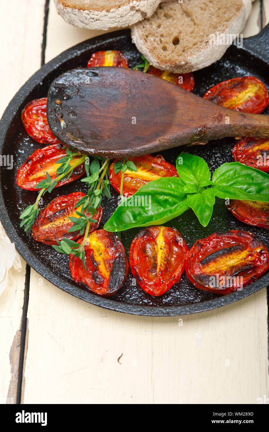 oven baked cherry tomatoes with basil and thyme on a cast iron skillet ...