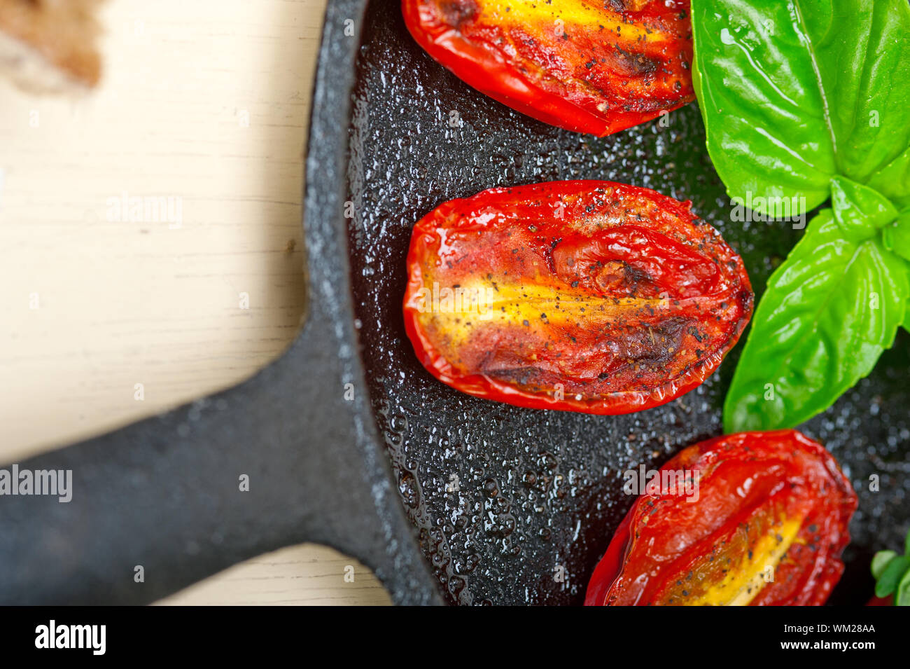 oven baked cherry tomatoes with basil and thyme on a cast iron skillet ...