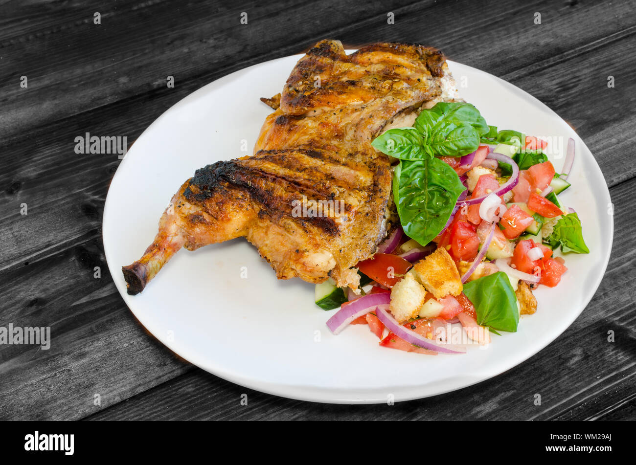 Chicken under a brick with panzanella salad. Pollo al mattone Stock ...