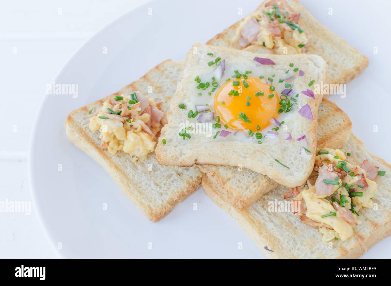 Fried egg inside toast with chive, ham and scrambled eggs Stock Photo ...
