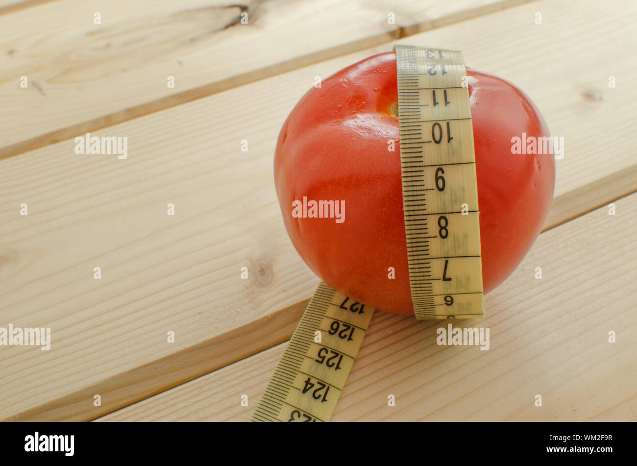 Simple picture of tomato with meter, on wood background Stock Photo - Alamy