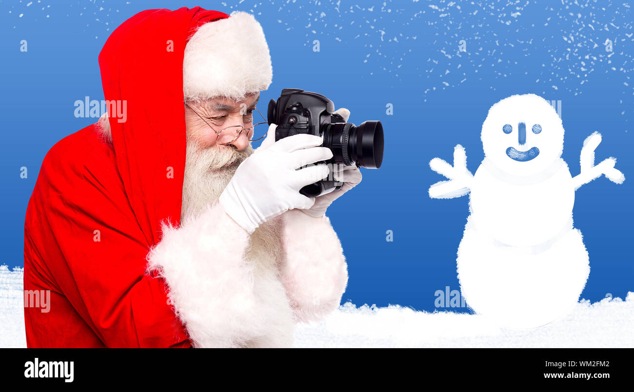 Santa taking a picture of snowman at winter Stock Photo - Alamy
