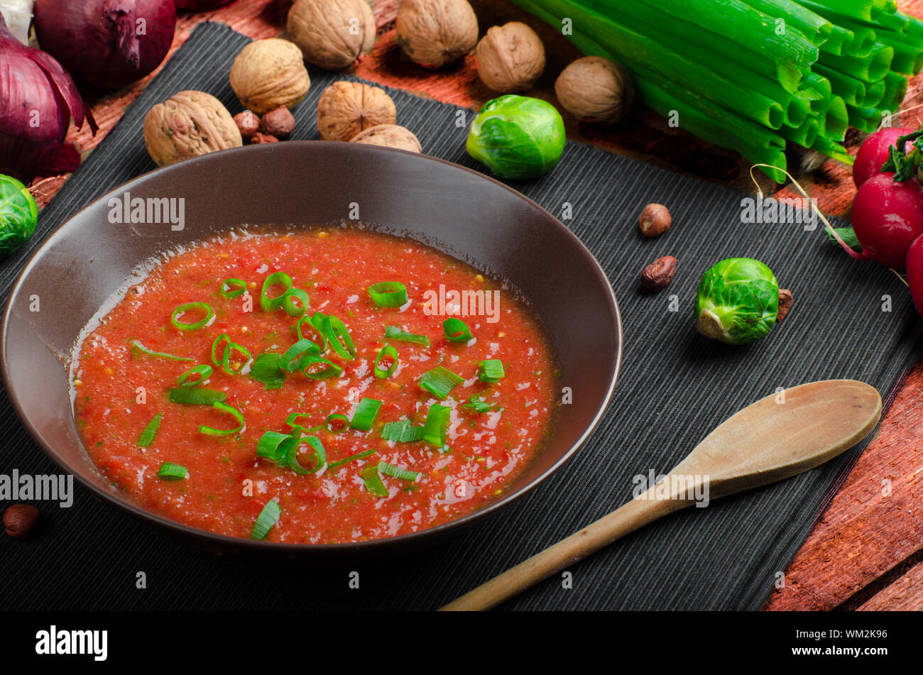 Hot salsa tomato with spring onion and red pepper on wood plate with ...