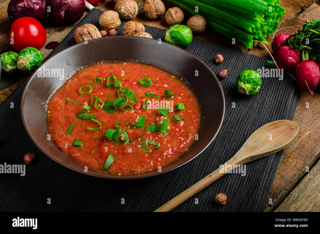 Hot salsa tomato with spring onion and red pepper on wood plate with ...