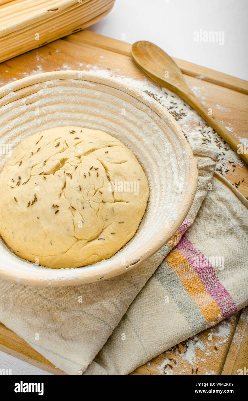 Making bread home in a basket - scuttle on white tablecloth Stock Photo ...