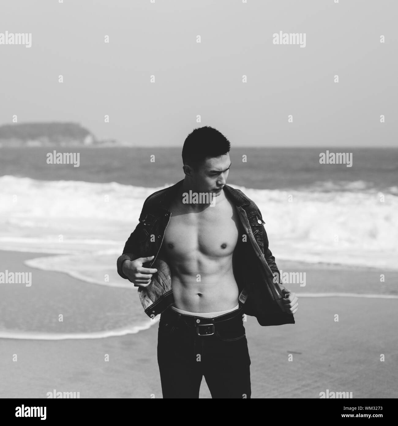 Man Removing Jacket At Beach Stock Photo - Alamy