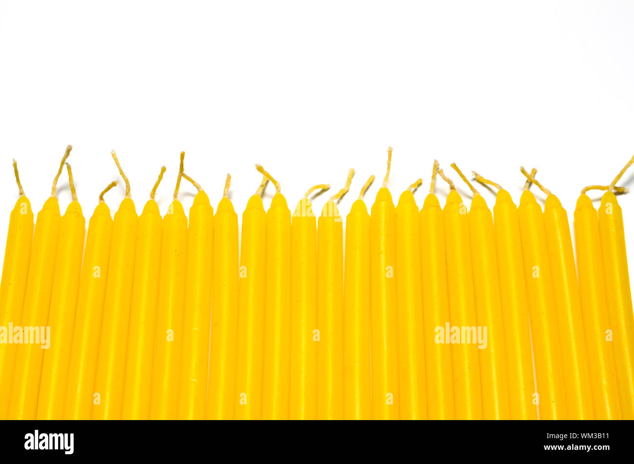 yellow candle on a white background Stock Photo - Alamy