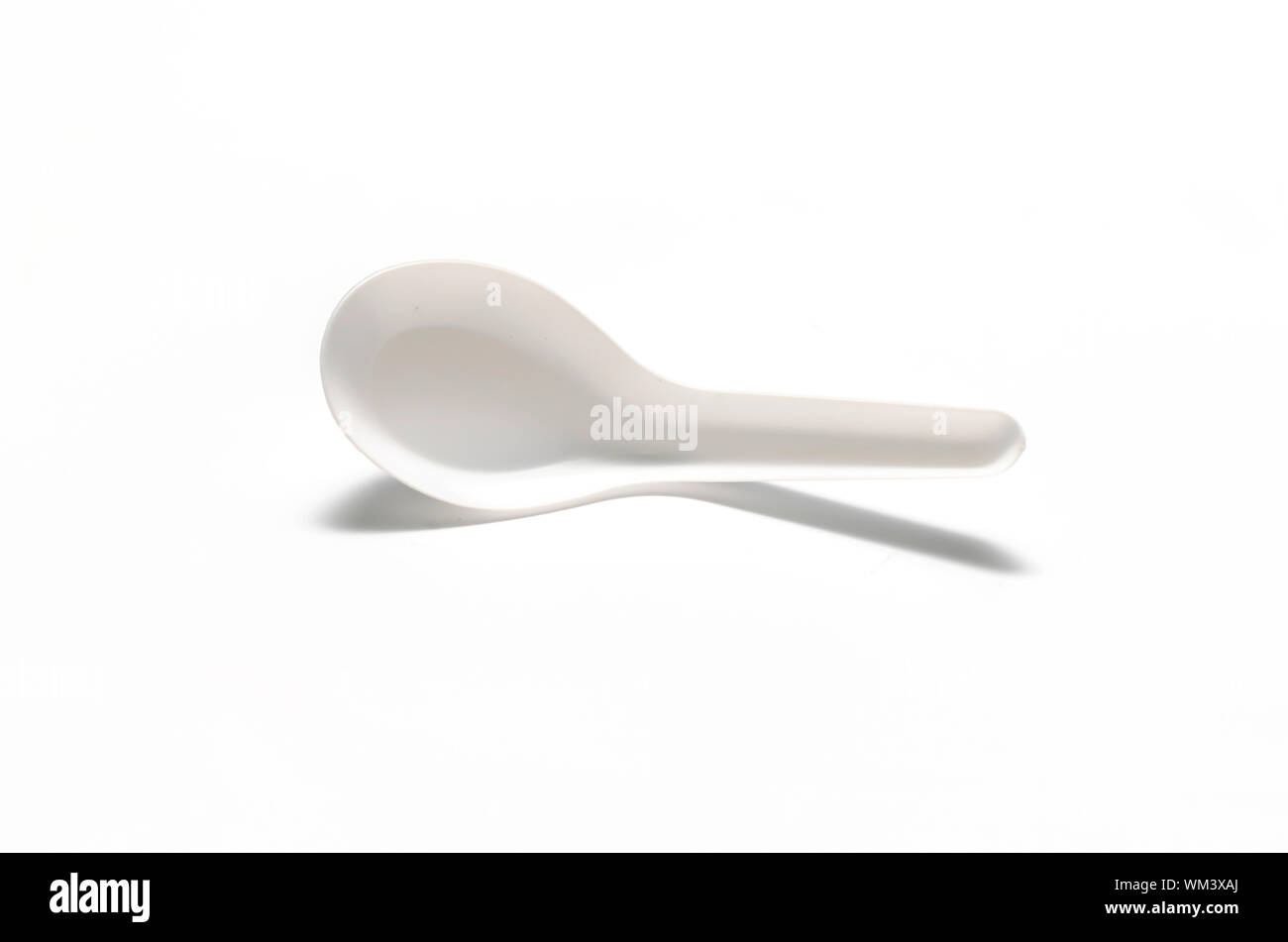 white plastic spoon on a white background Stock Photo - Alamy