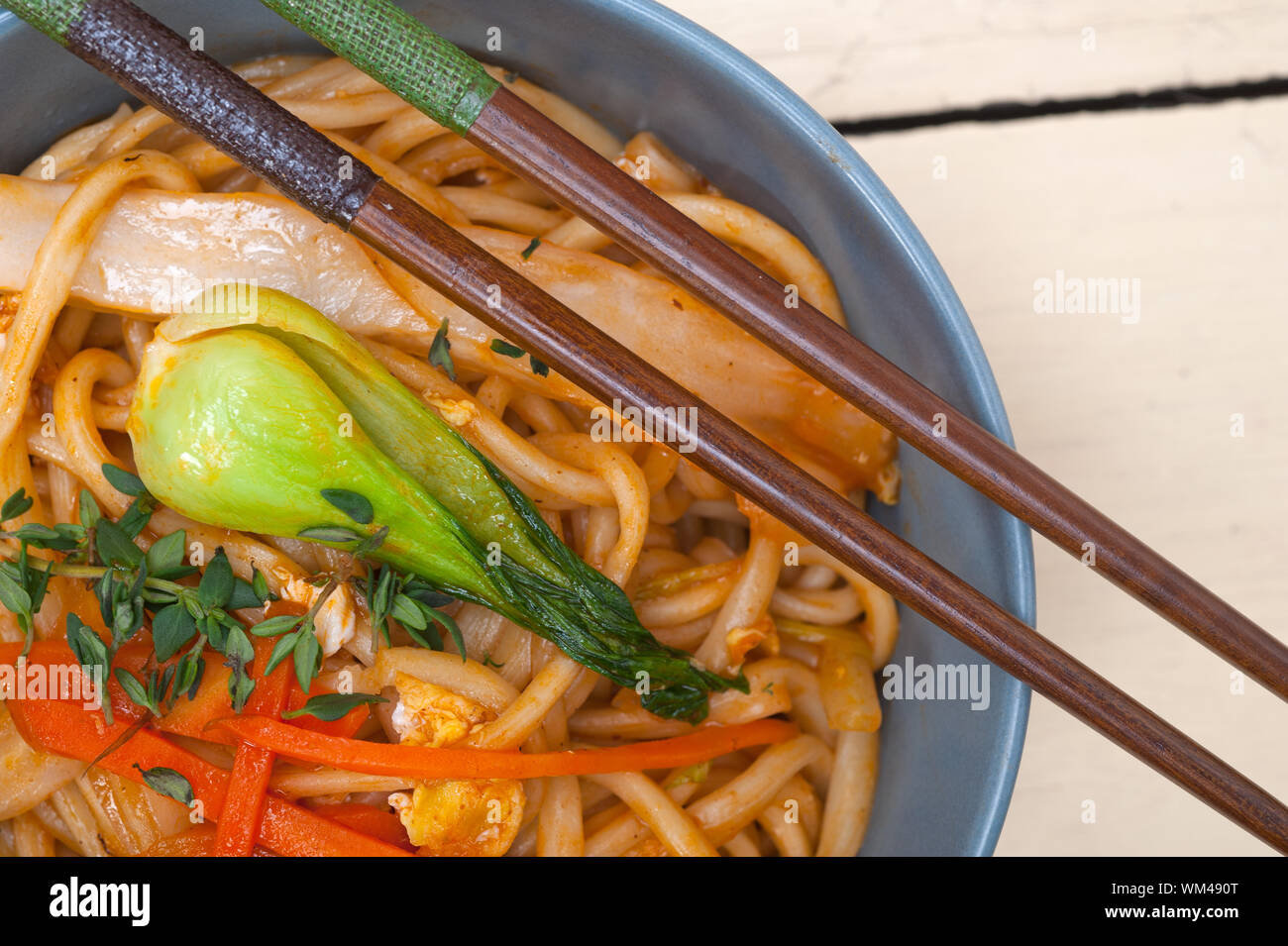 hand pulled stretched Chinese ramen noodles on a bowl with chopstick ...