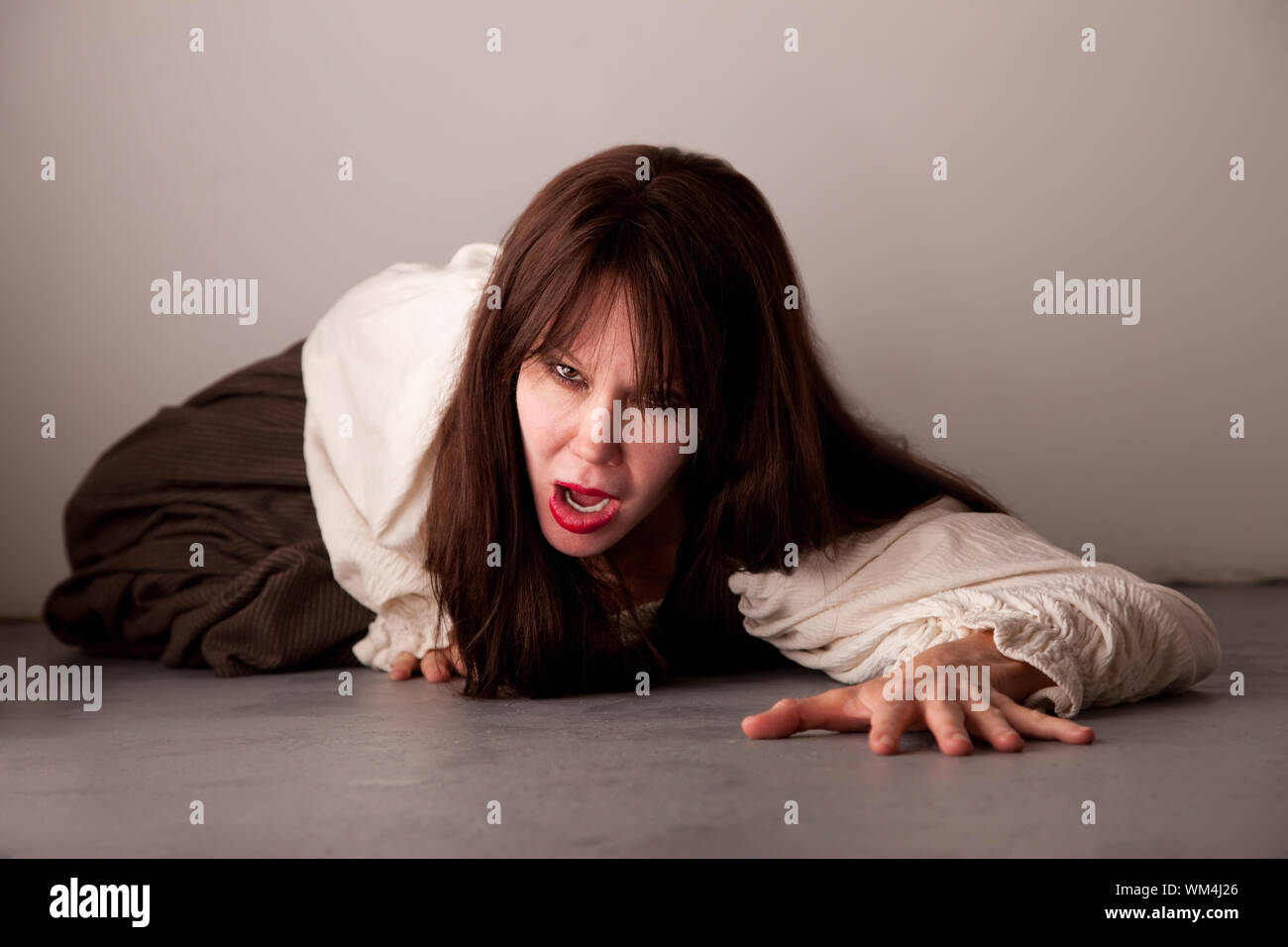 Beautiful female horror movie style victim crawling on the floor Stock ...