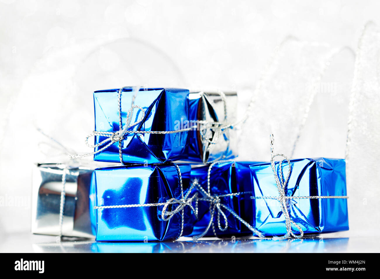 Decorative blue boxes with holiday gifts on shiny glitter background ...
