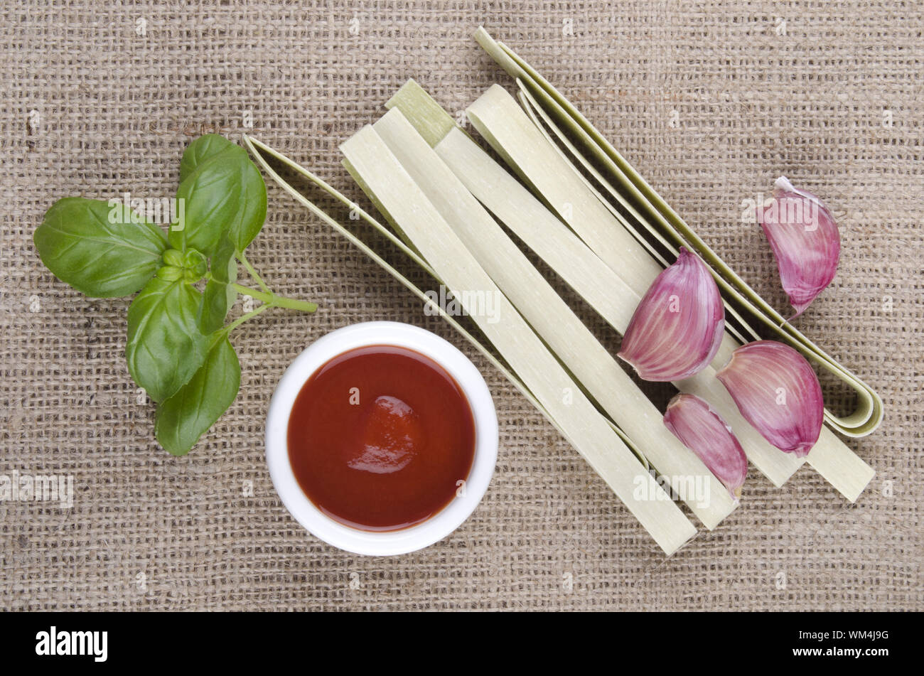 pappardelle pasta, basil, tomato puree and garlic on brown jute Stock ...