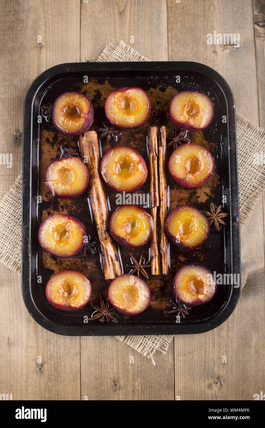 baked plums with anise and cinnamon sticks on a baking tray Stock Photo ...