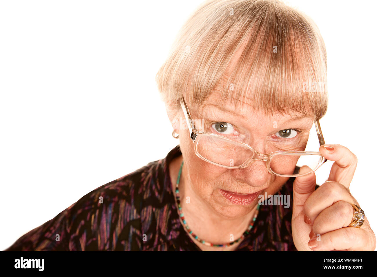 Skeptical senior woman looking over the top of her glasses Stock Photo ...
