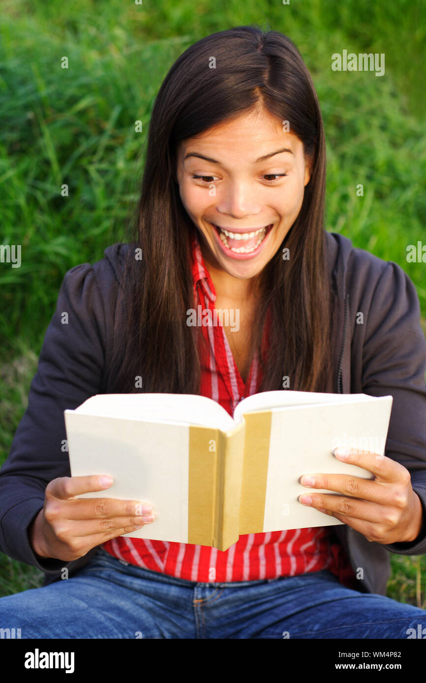woman surprised by the story she is reading in the book Stock Photo - Alamy