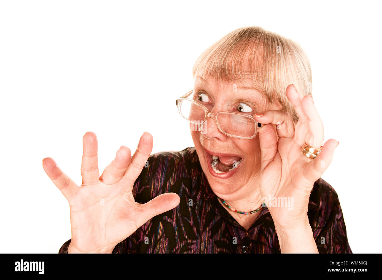 Shocked senior woman looking sideways over the top of her glasses Stock ...