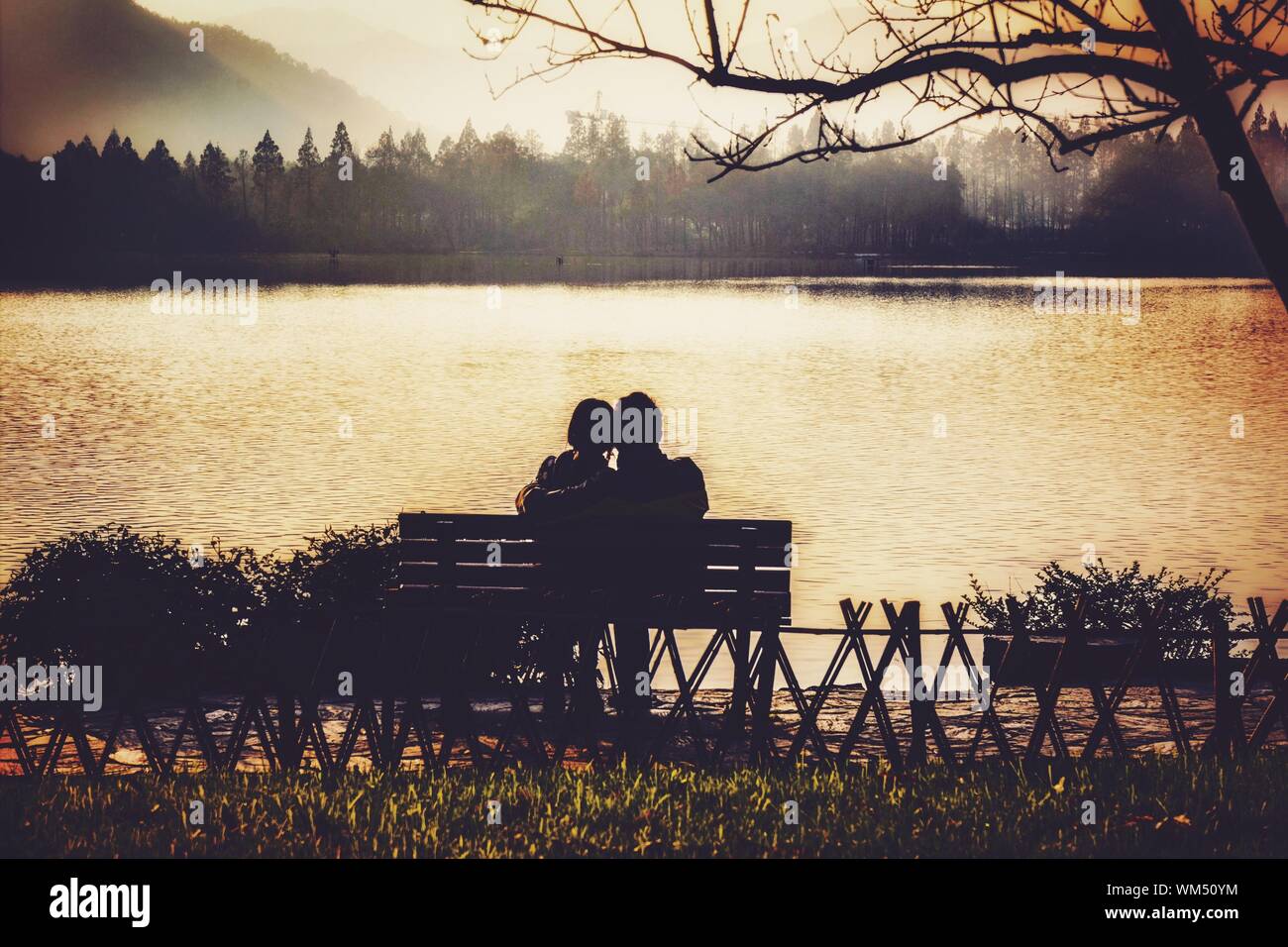 Couple sitting on bench at sunset hi-res stock photography and images ...