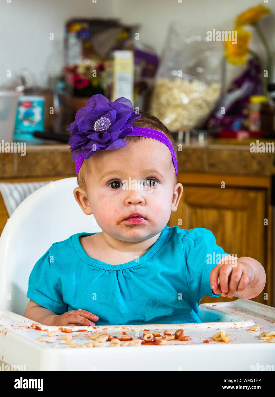 Messy baby eats her breakfast in the kitchen Stock Photo - Alamy