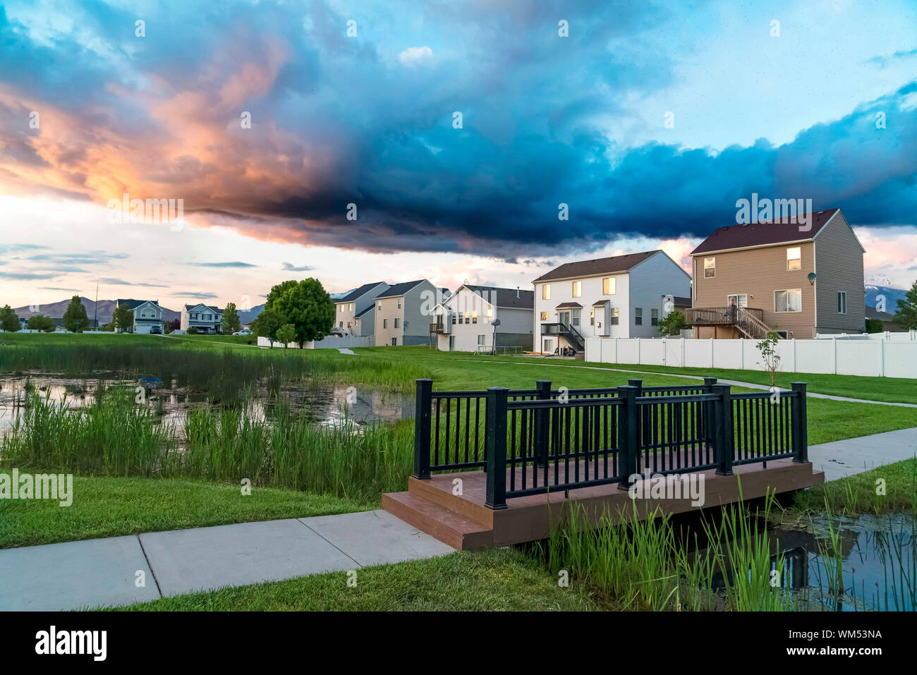 Scenic view of a residential area with a bridge and shiny pond in the ...