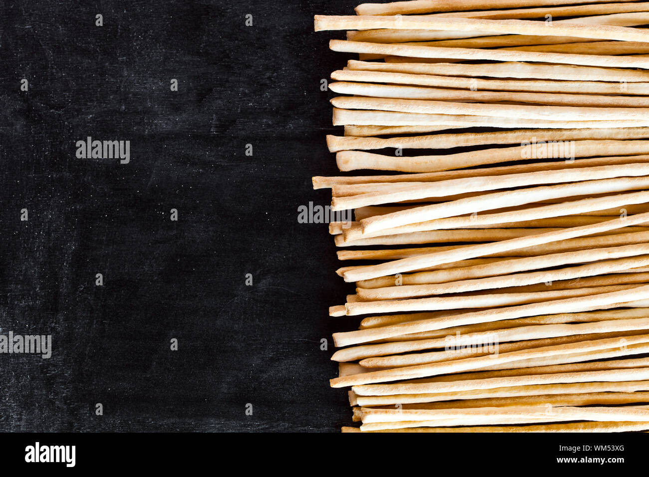 top view of breadsticks grissini torinesi on blackboard background ...