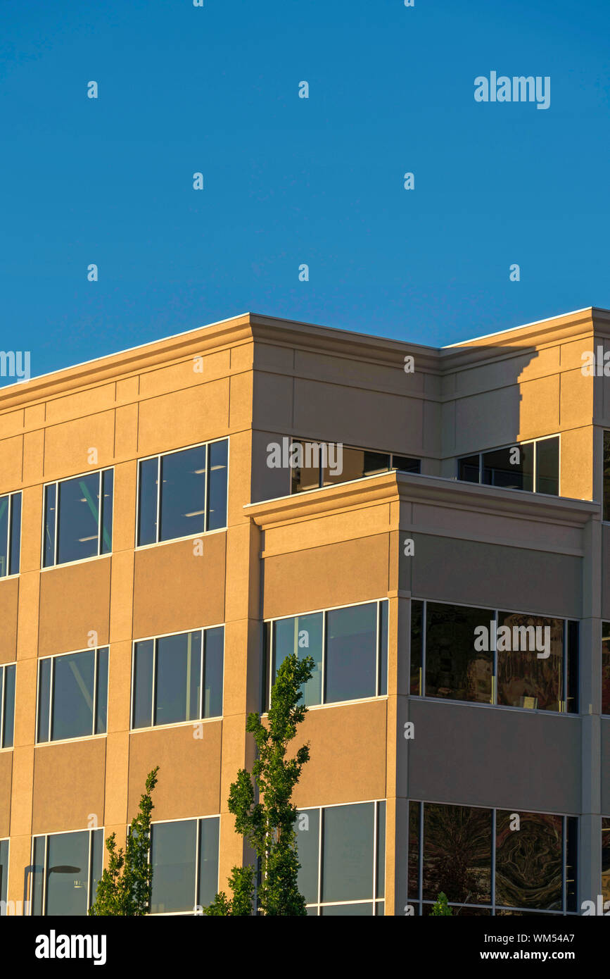 Modern building exterior with concrete wall and shiny windows on a ...