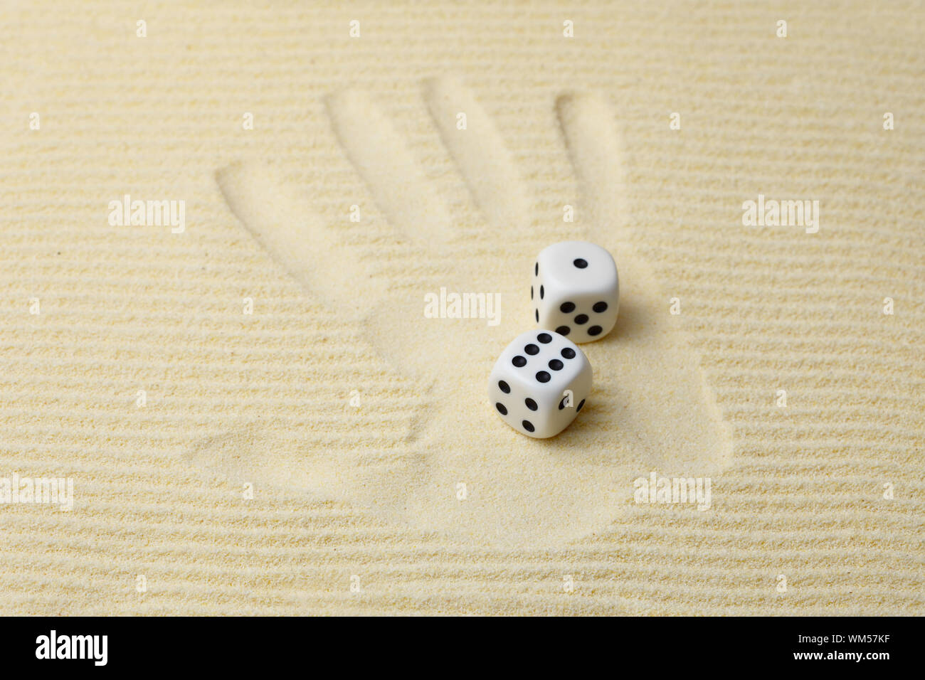 Print of a palm on sand with dices Stock Photo - Alamy