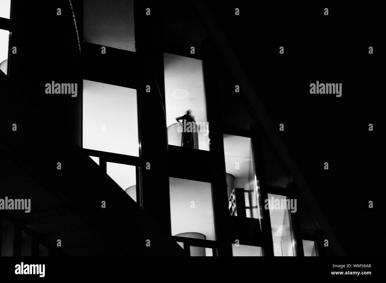 Low Angle View Of Silhouette Person Standing At Window Stock Photo - Alamy