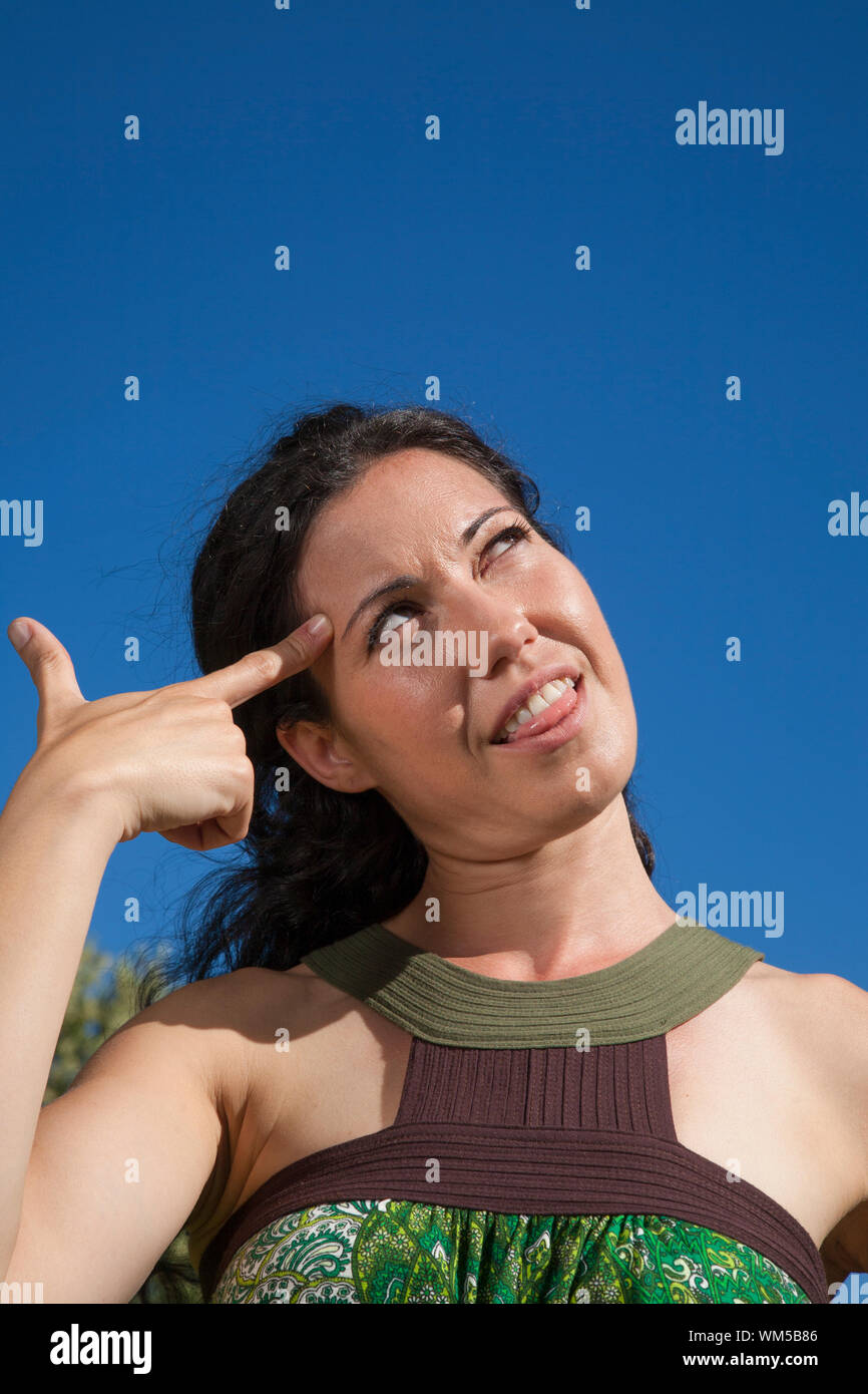 woman gesticulating crazy finger symbol in head Stock Photo - Alamy