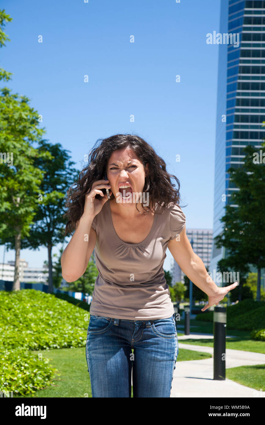 portrait of angry woman shouting to mobile at street Stock Photo - Alamy