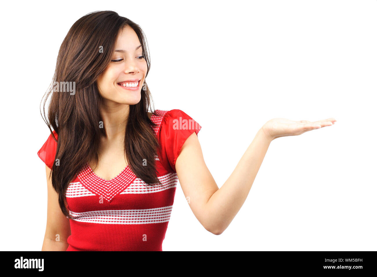 Woman showing product .Beautiful casual young woman holding out her ...