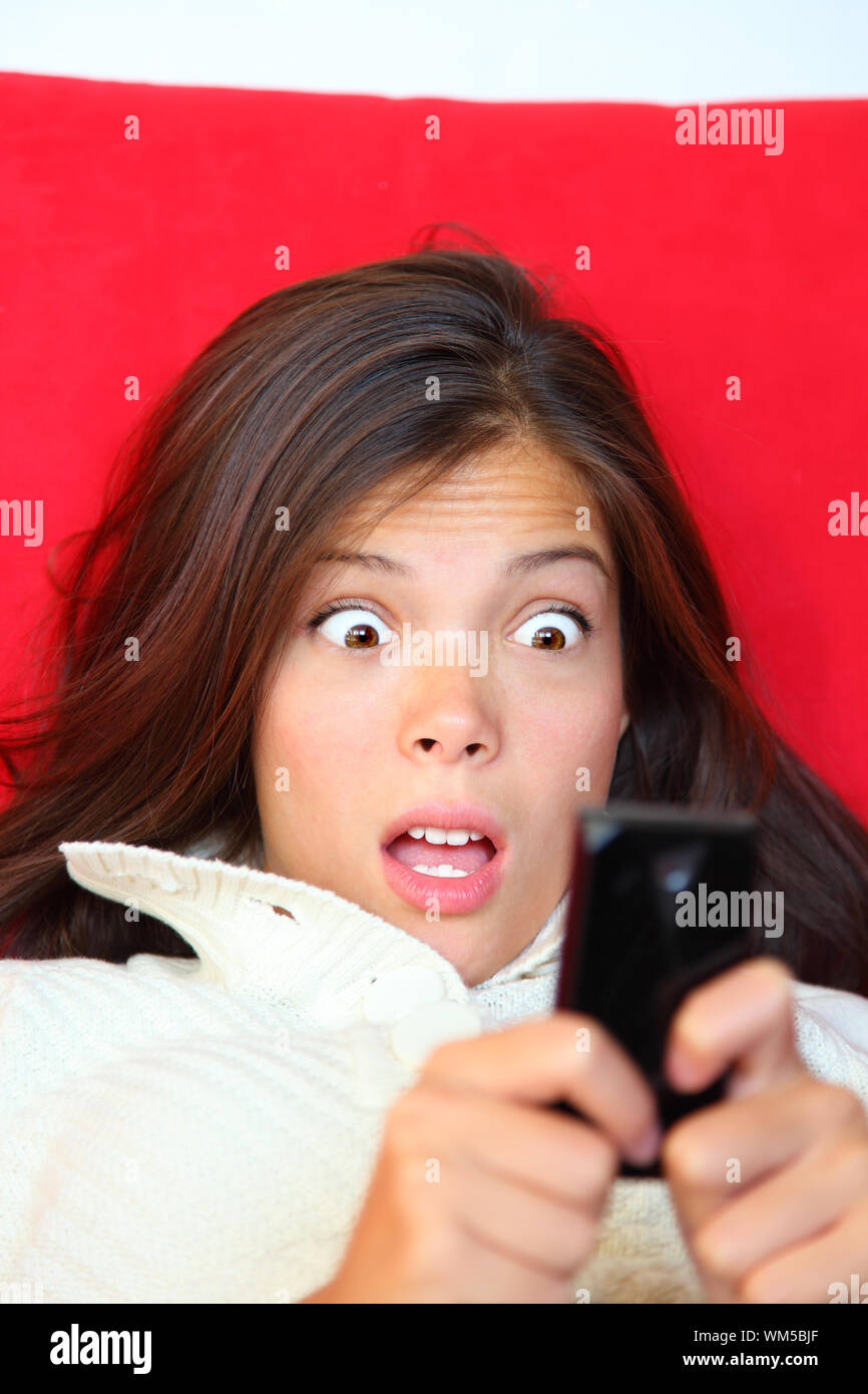 Surprised woman reading shocking sms text message Stock Photo - Alamy