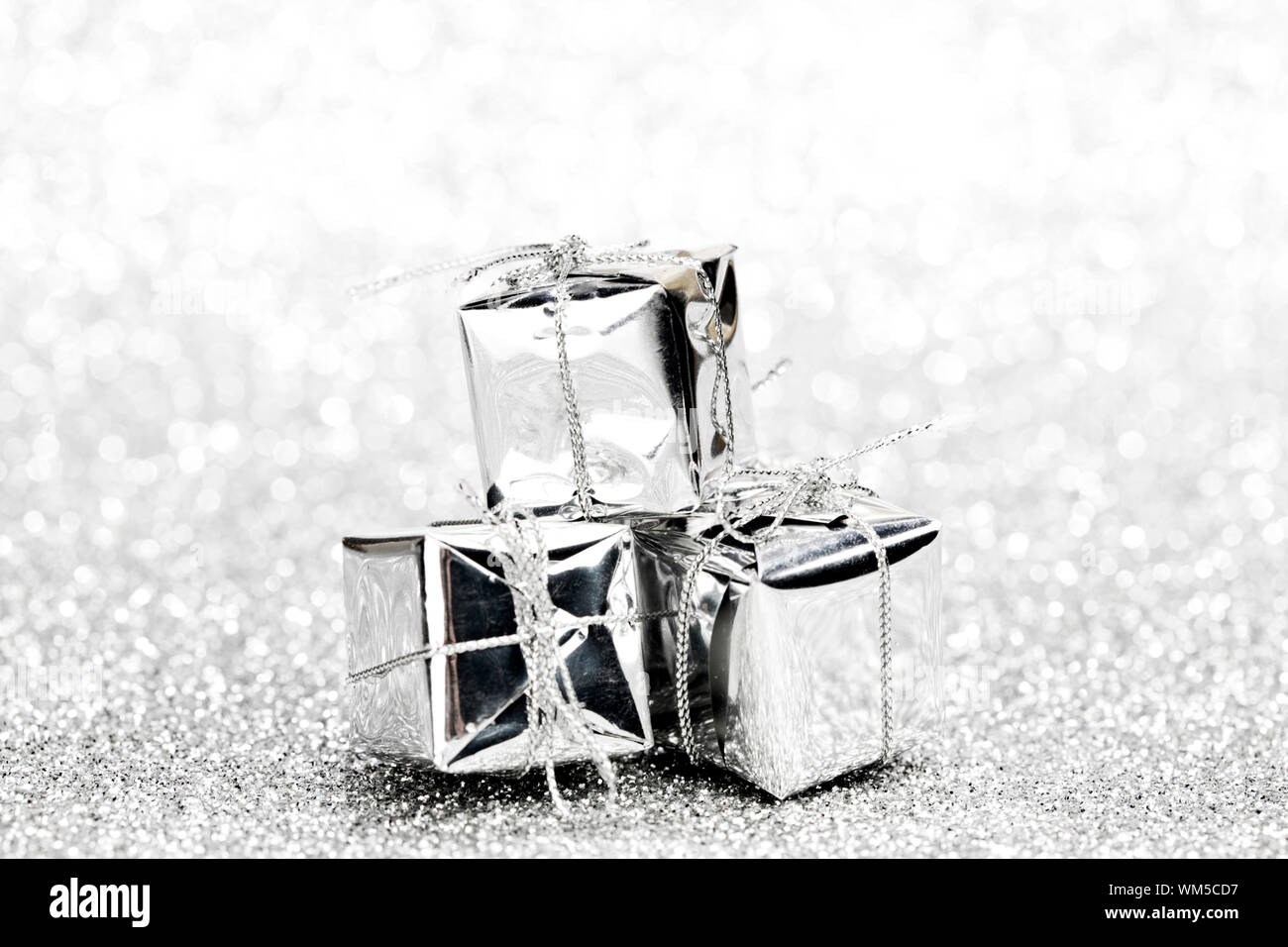 Decorative silver boxes with holiday gifts on shiny glitter background ...