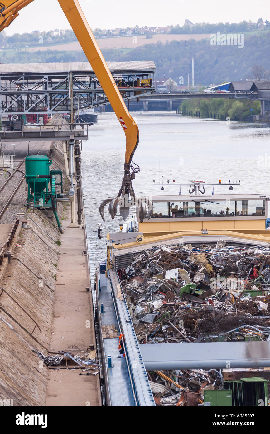 Open barge being loaded or offloaded at a wharf on an urban waterway or ...