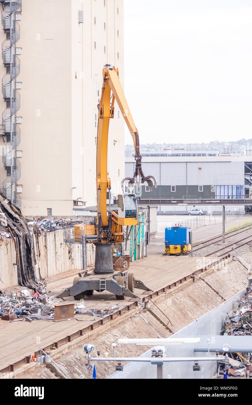 Open barge being loaded or offloaded at a wharf on an urban waterway or ...