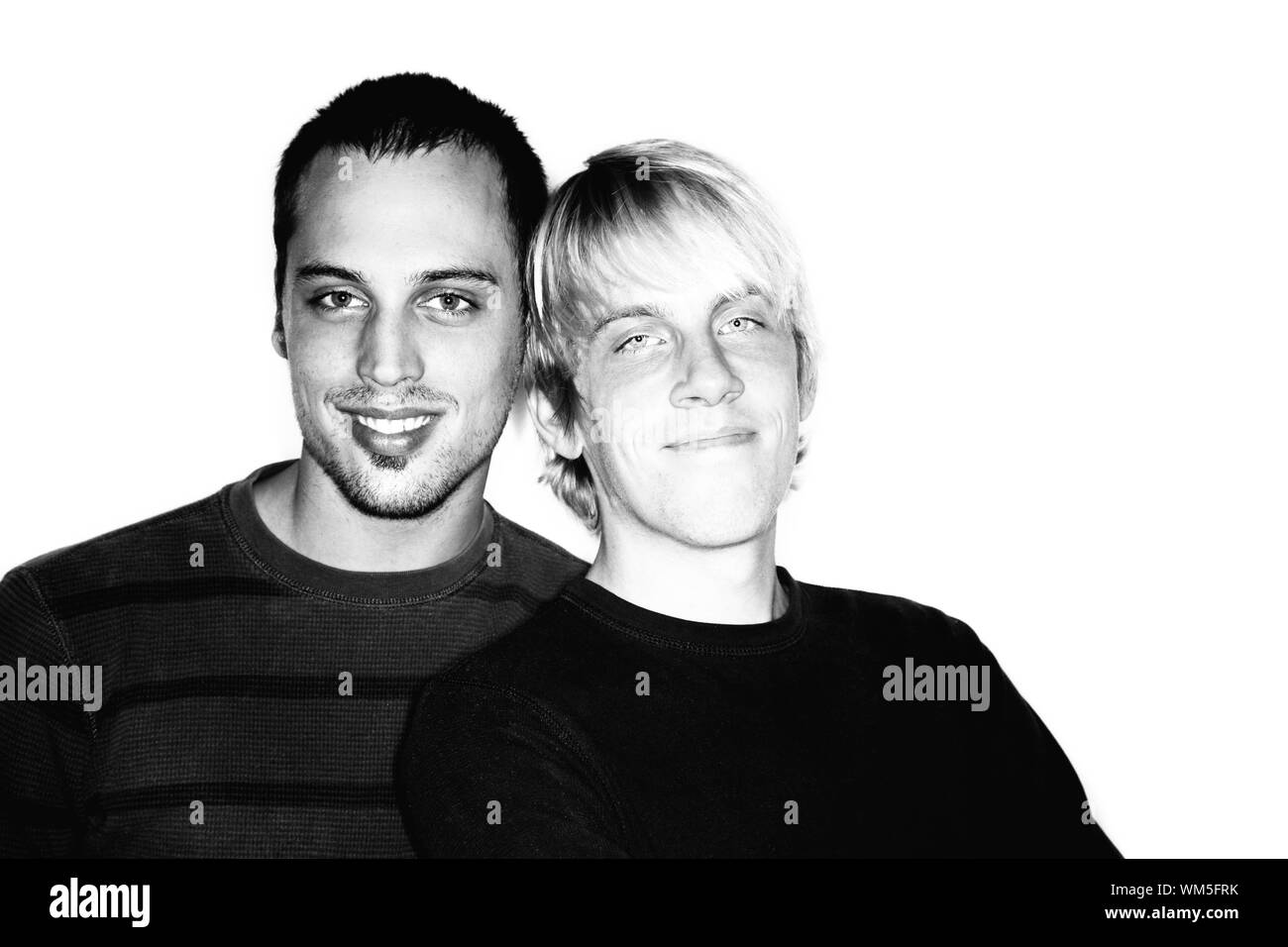 Two handsome men posing for portrait on white background Stock Photo ...