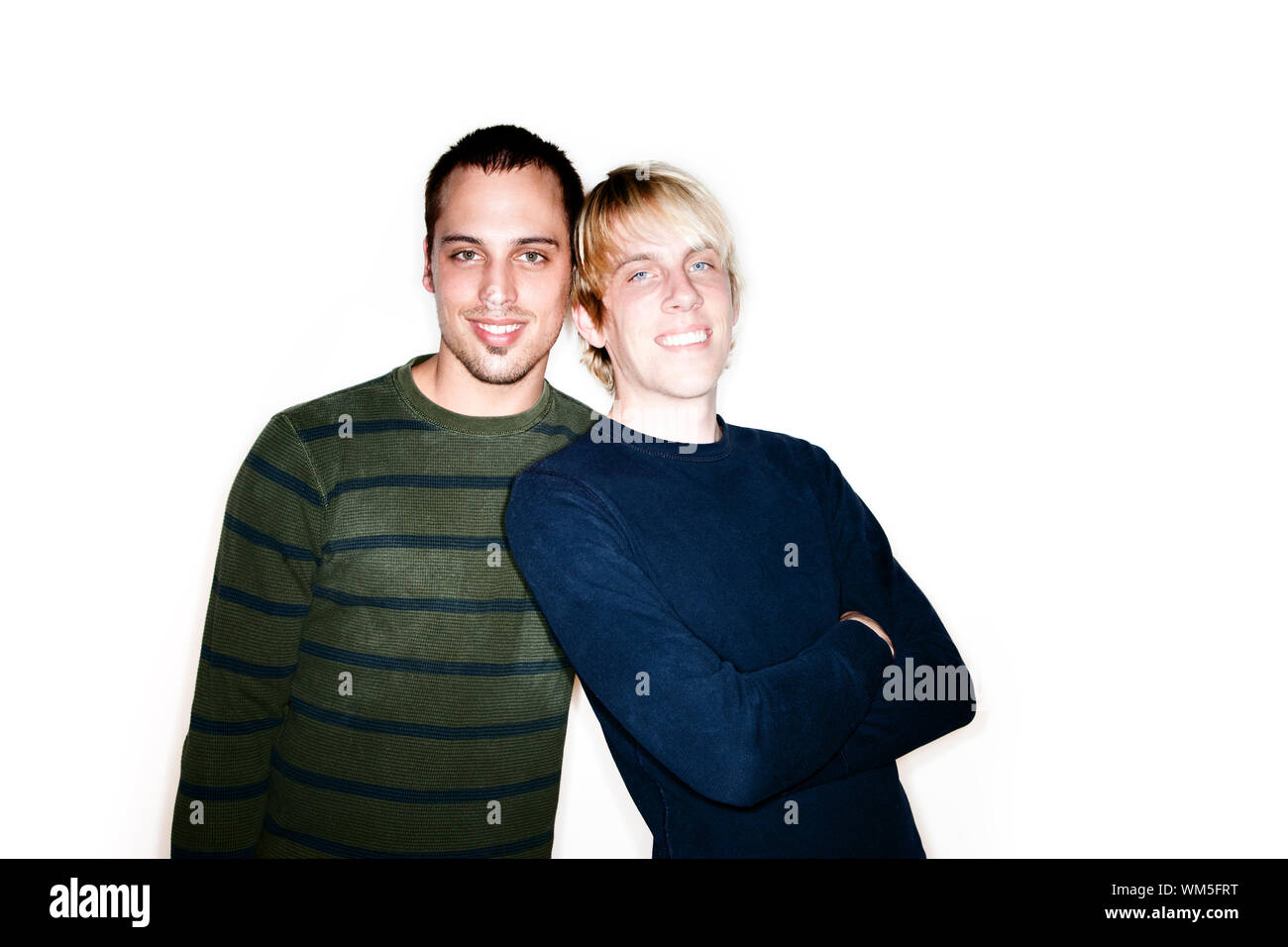 Two handsome men posing for portrait on white background Stock Photo ...