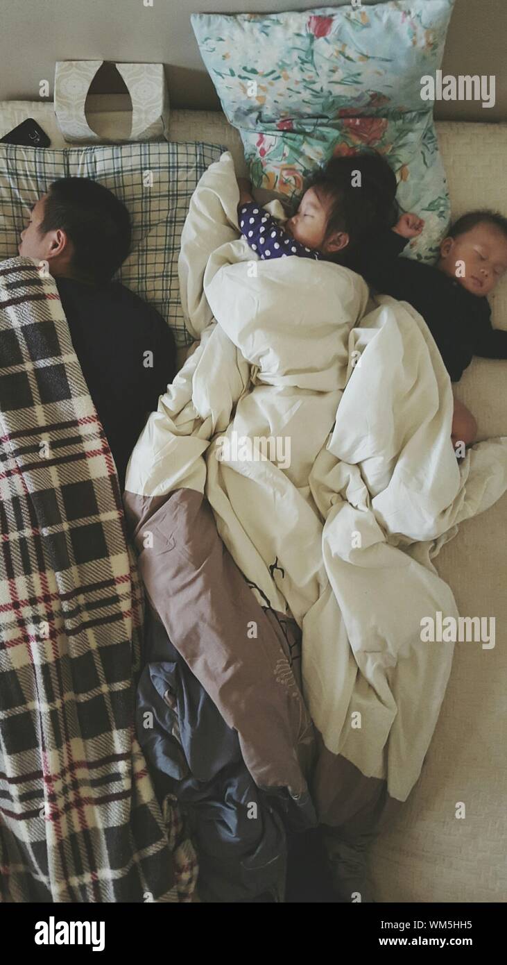 Family Sleeping On Bed At Home Stock Photo - Alamy